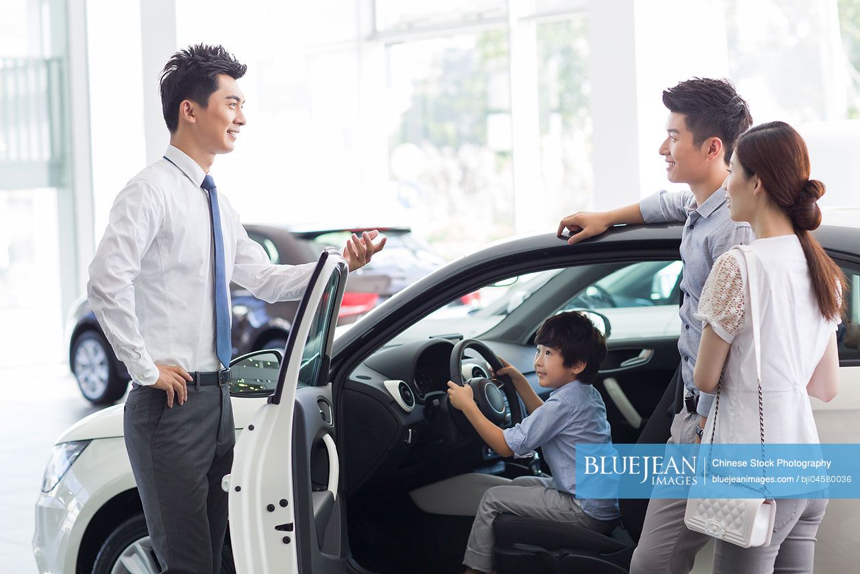 Young Chinese family choosing car in showroom-High-res stock photo for ...