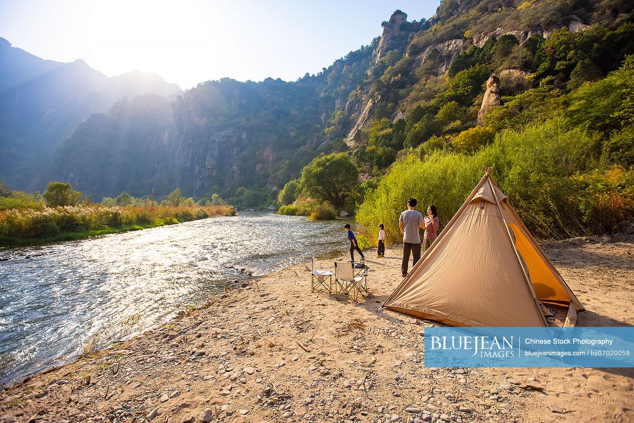 Happy young Chinese family camping outdoors-High-res stock photo for ...
