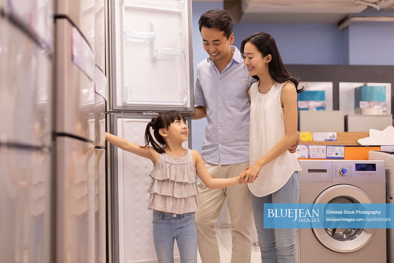 Happy young Chinese family shopping in supermarket-High-res stock photo ...