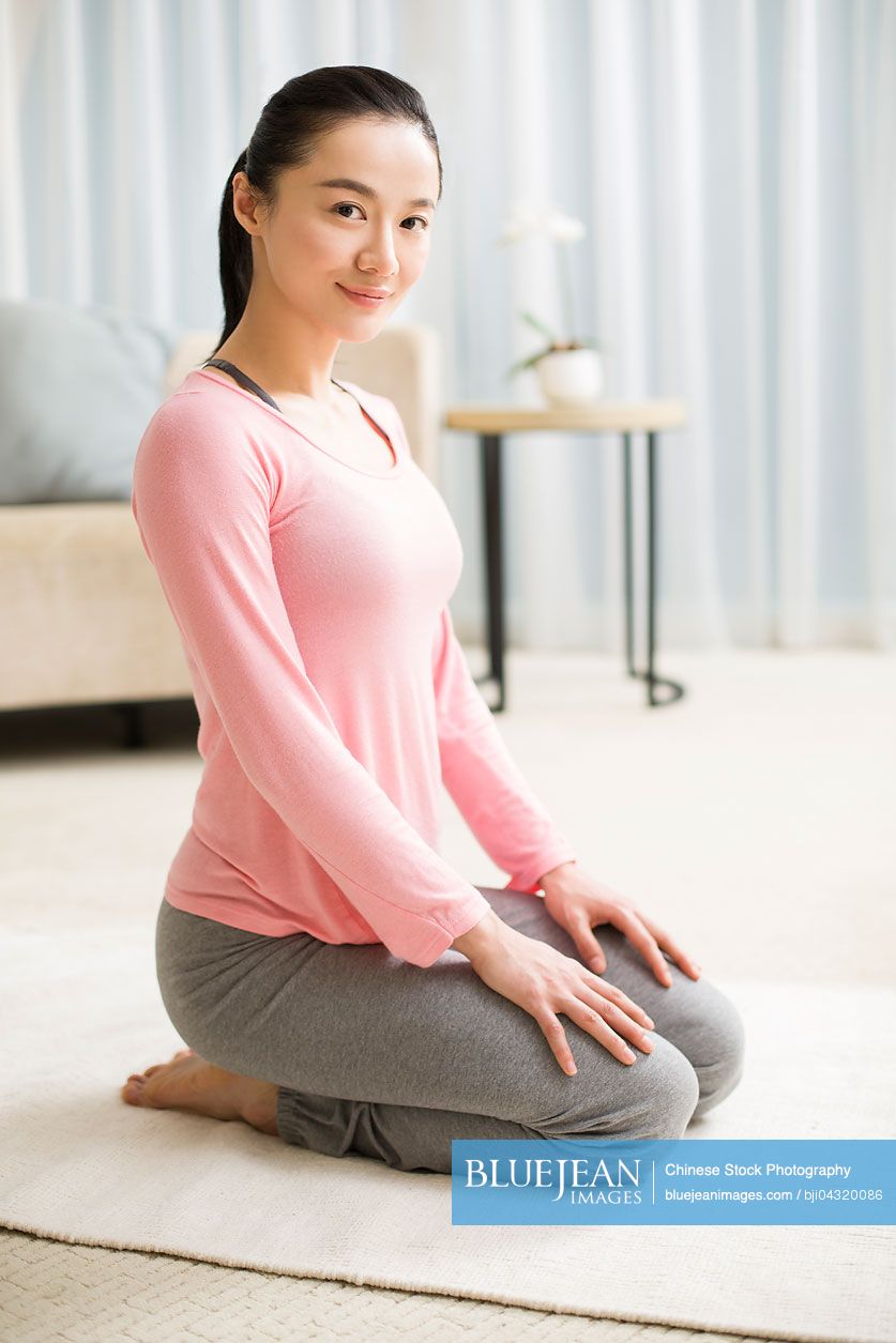 Young Chinese woman practicing yoga in living room-High-res stock photo ...