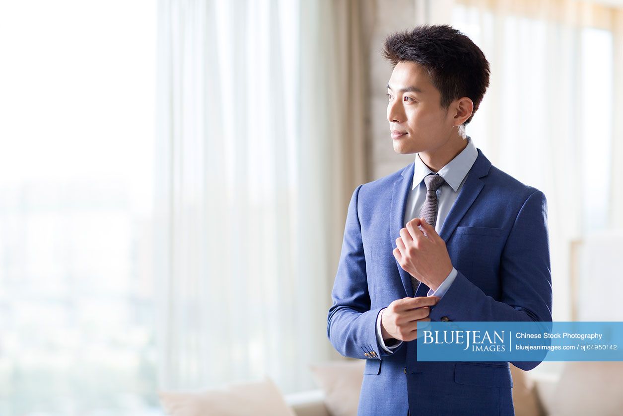 Young Chinese businessman getting dressed in the morning-High-res stock ...