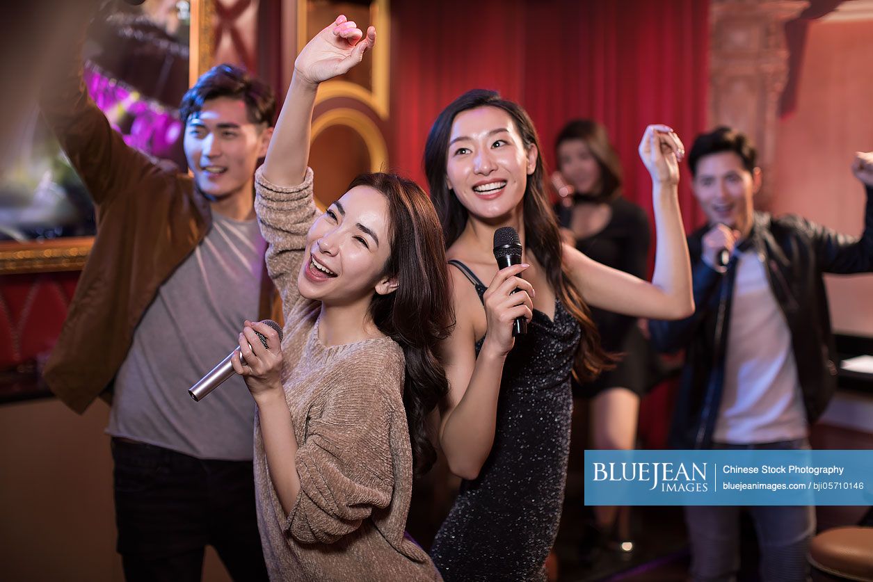 Happy Chinese friends singing karaoke in nightclub-High-res stock photo ...
