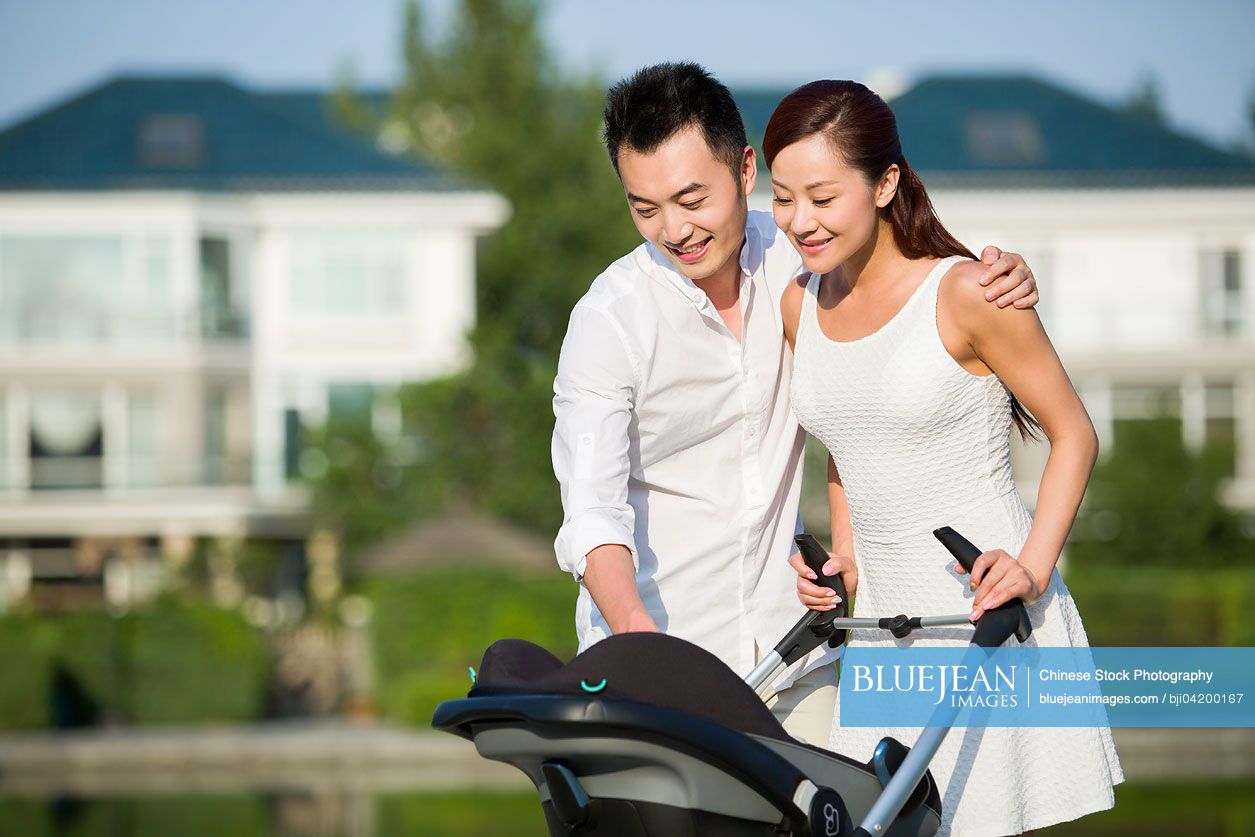 Young Chinese couple taking a walk with their baby in pram-High-res ...