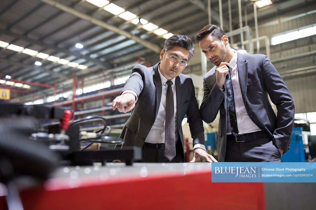 Businessman and engineer checking machine parts in the factory-High-res ...