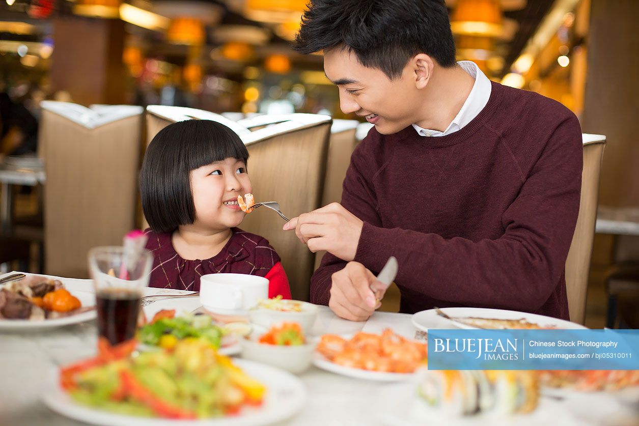 Cheerful Chinese father and daughter having buffet dinner-High-res ...
