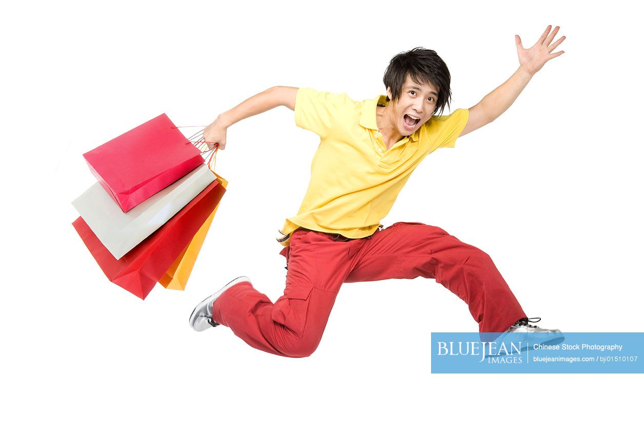 Young Chinese man running with shopping bags-High-res stock photo for ...