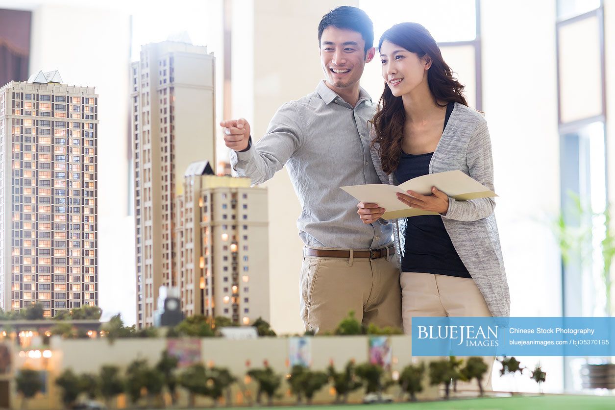 Happy young Chinese couple buying new house from sales center-High-res ...