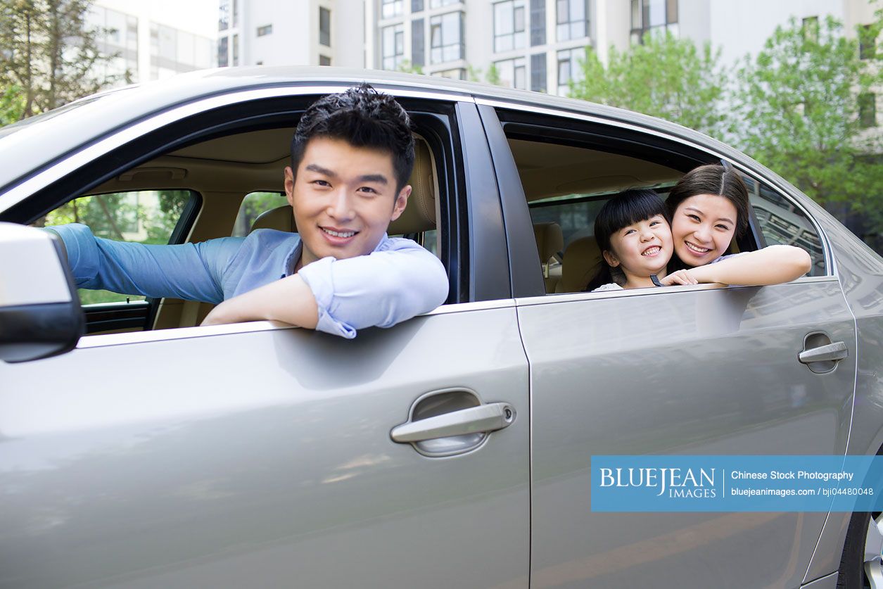 Happy young Chinese family in a car-High-res stock photo for download