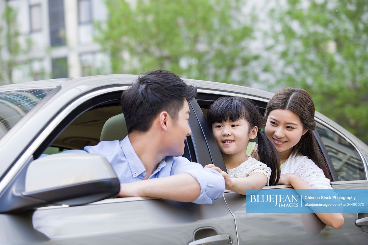 Happy young Chinese family in a car-High-res stock photo for download