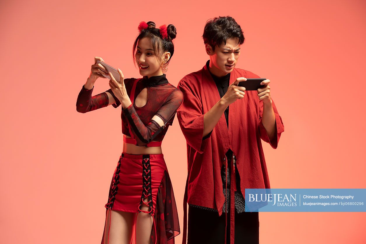 Young Chinese couple playing mobile games-High-res stock photo for download