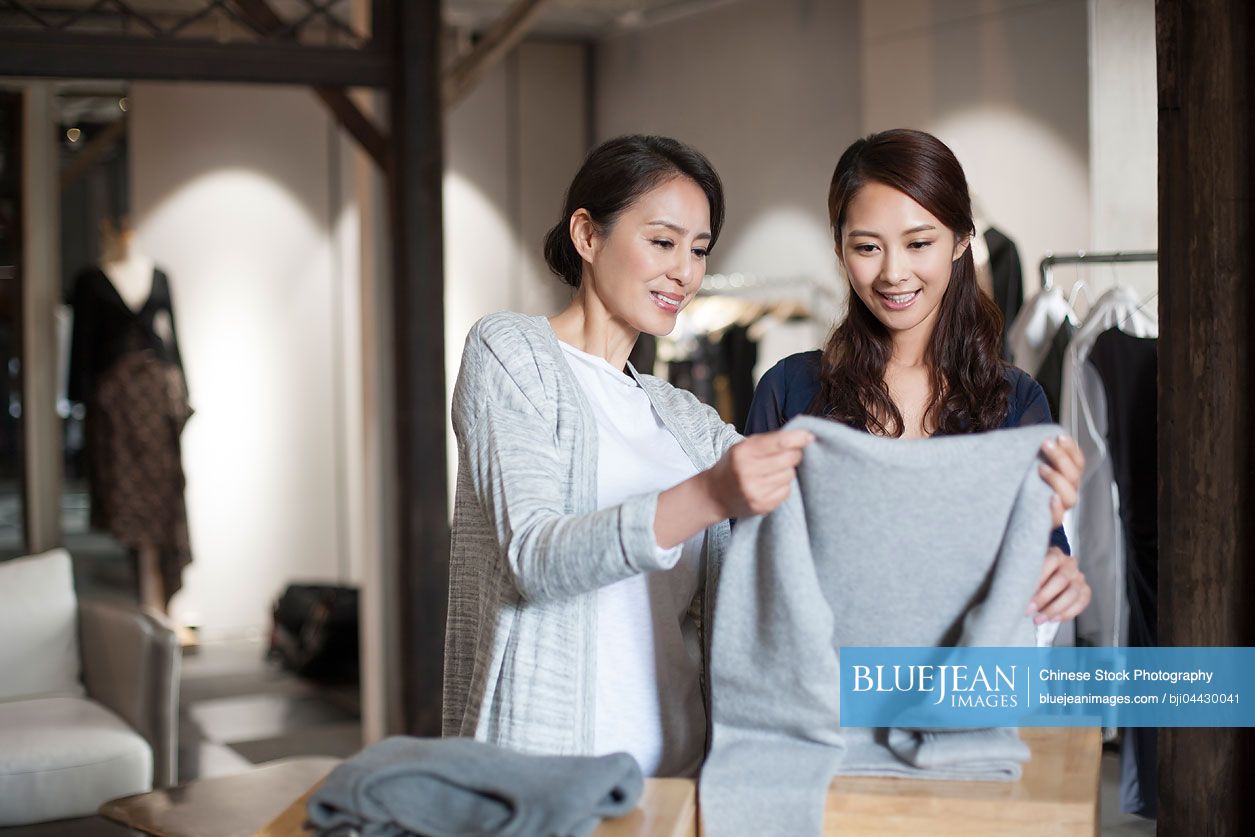 Chinese clothing store owner showing customer Chinese clothing-High-res ...