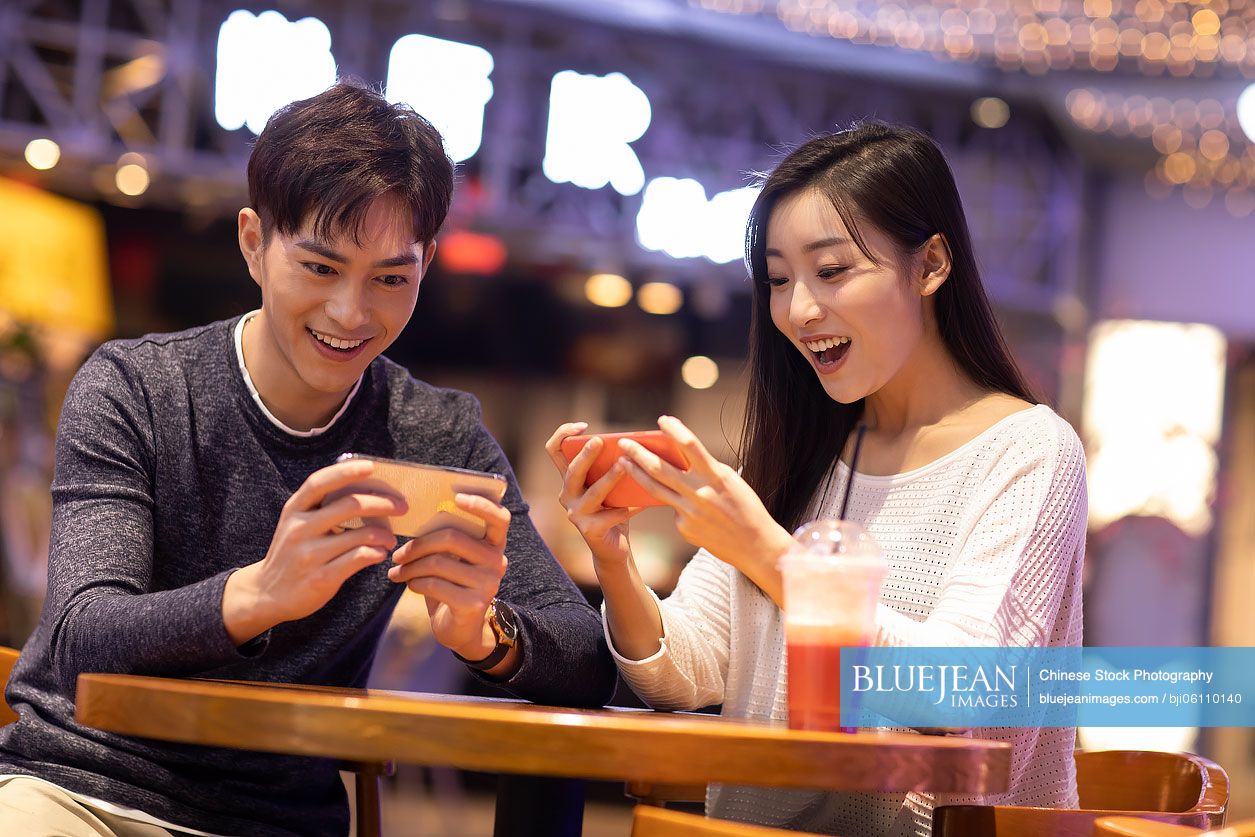 Happy young Chinese couple playing mobile games-High-res stock photo ...
