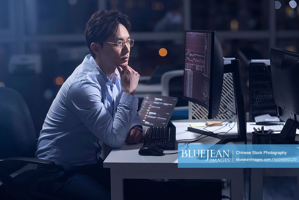 Chinese businessman working in office at night-High-res stock photo for download