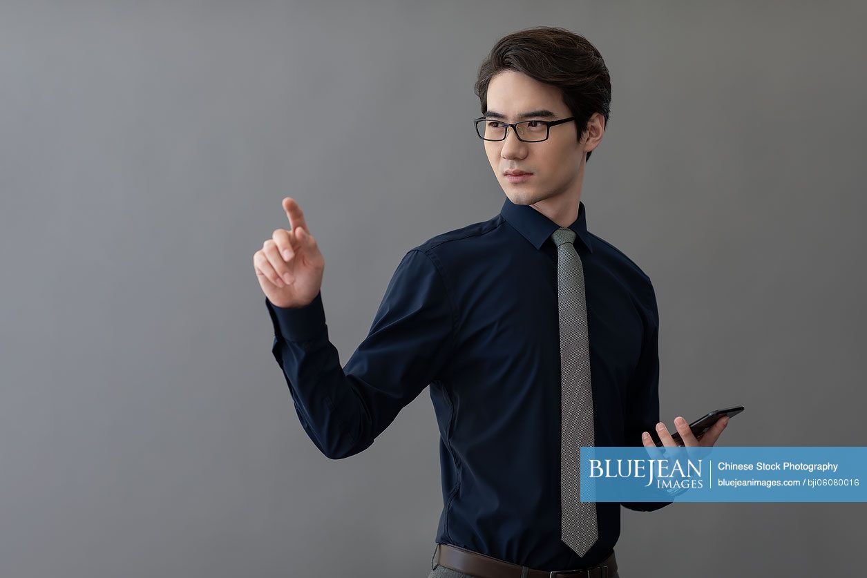 Young Chinese businessman using advanced touch screen technology-High ...