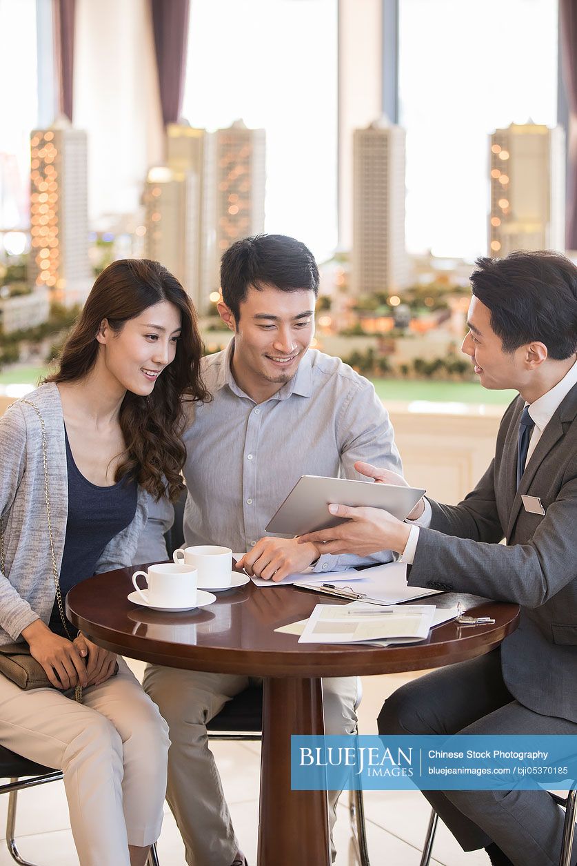 Happy young Chinese couple buying new house from realtor-High-res stock photo for download