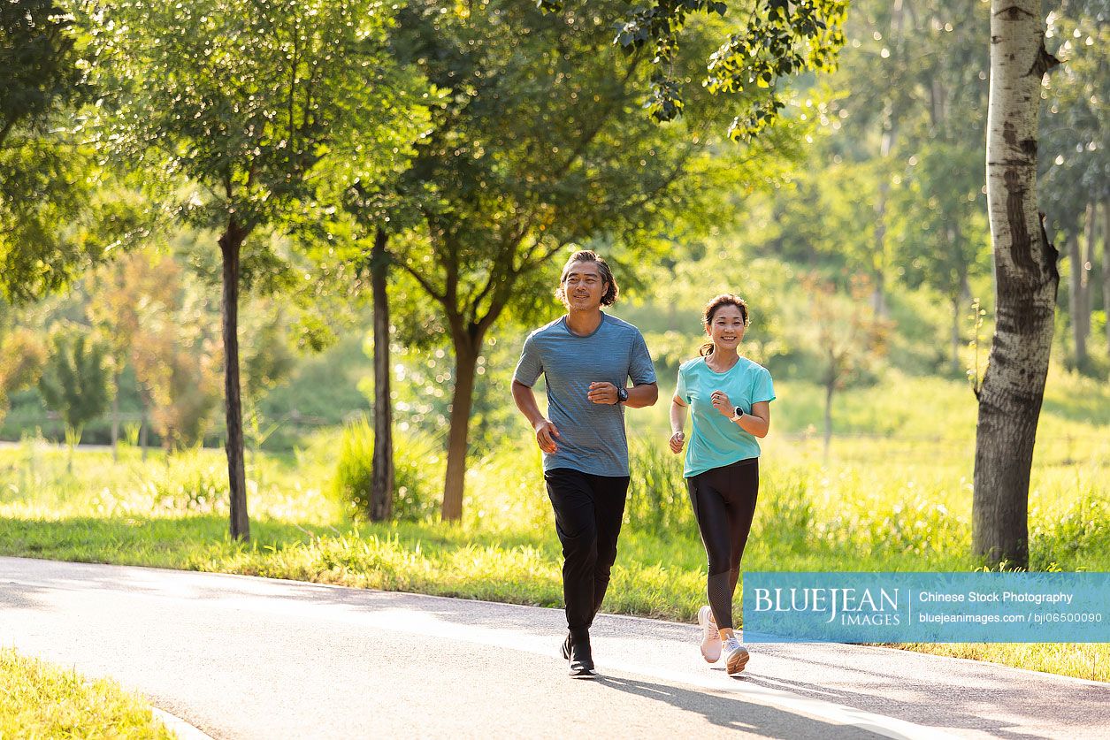 Happy mature Chinese couple running in park-High-res stock photo for download