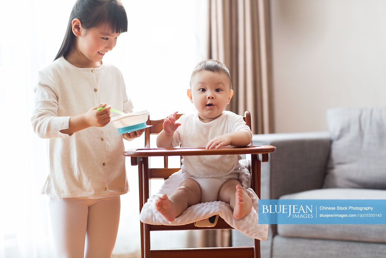 Little Chinese girl feeding baby-High-res stock photo for download