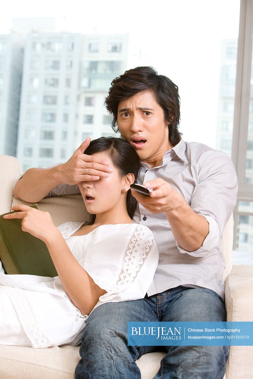Chinese couple cuddling on a sofa-High-res stock photo for download