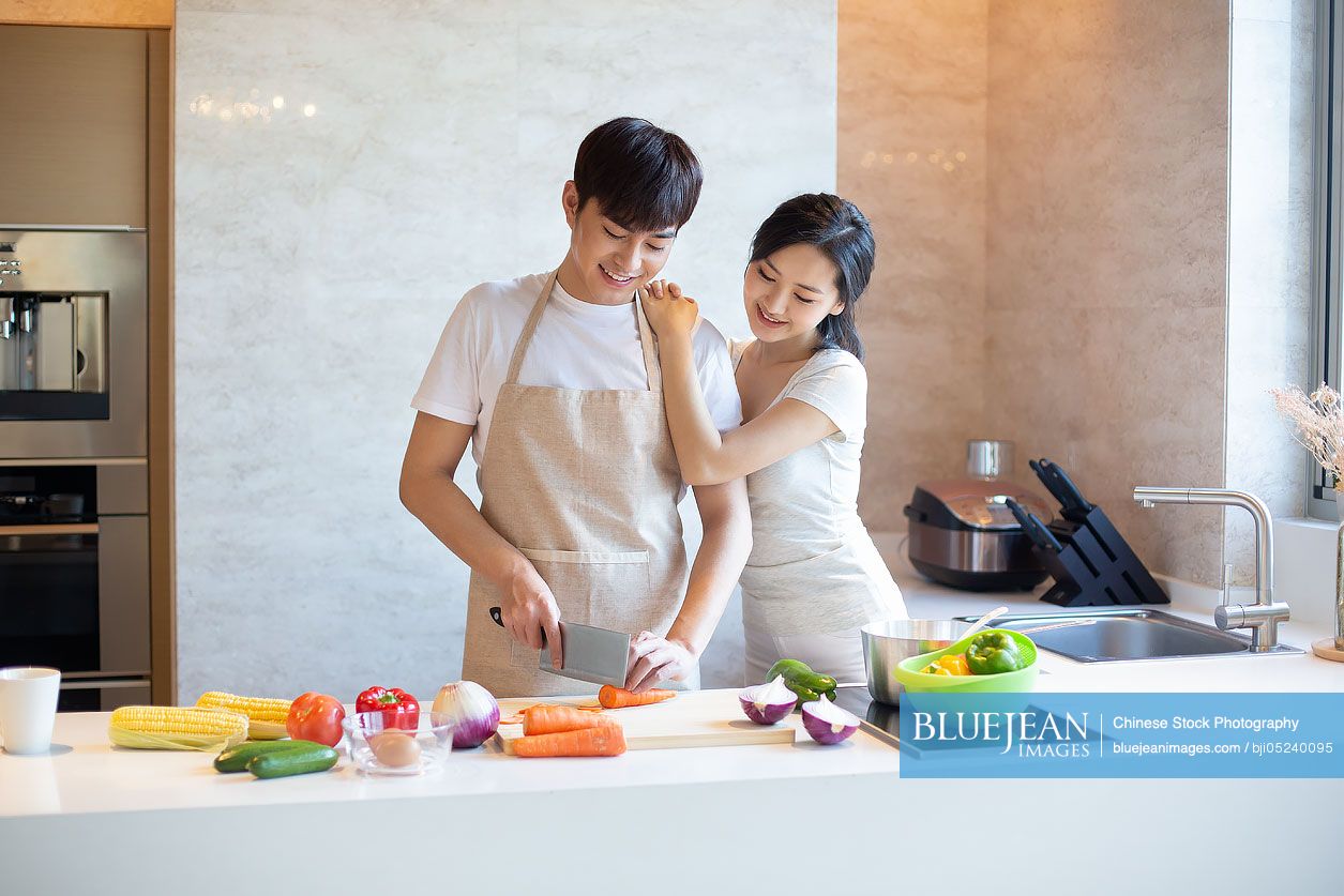 Happy young Chinese couple cooking in kitchen-High-res stock photo for ...