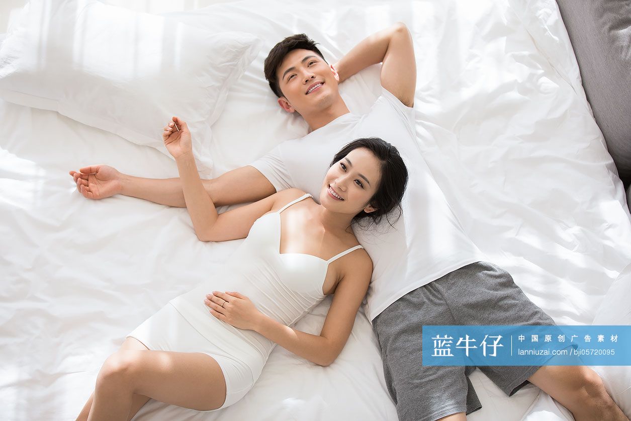 快乐的年轻情侣躺在床上 蓝牛仔影像 中国原创广告影像素材