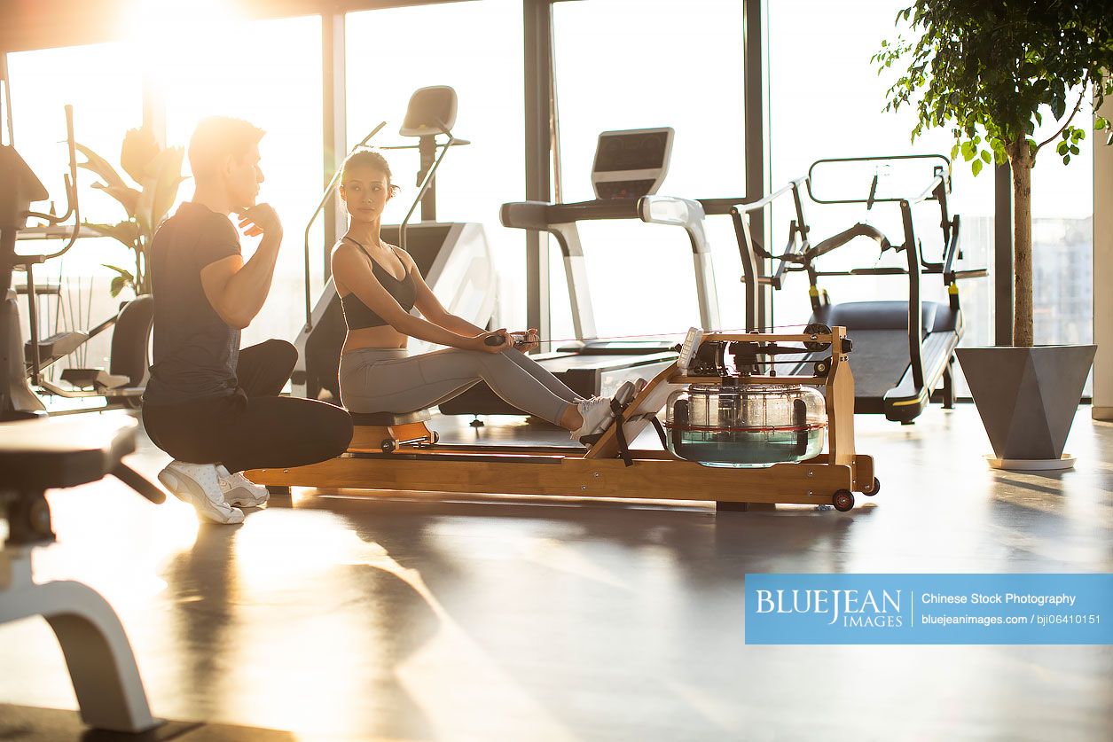 Young Chinese woman working out with personal trainer at gym-High-res ...