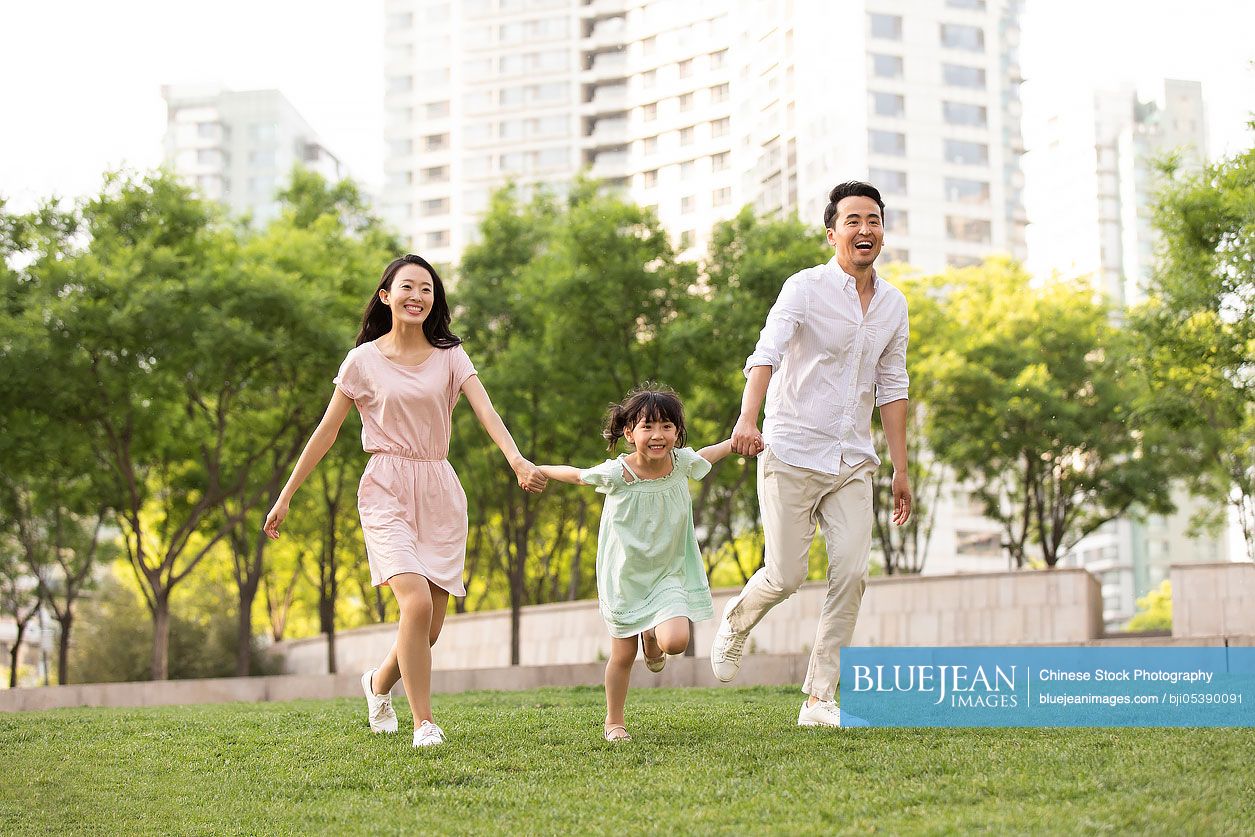 Happy young Chinese family playing in park-High-res stock photo for download