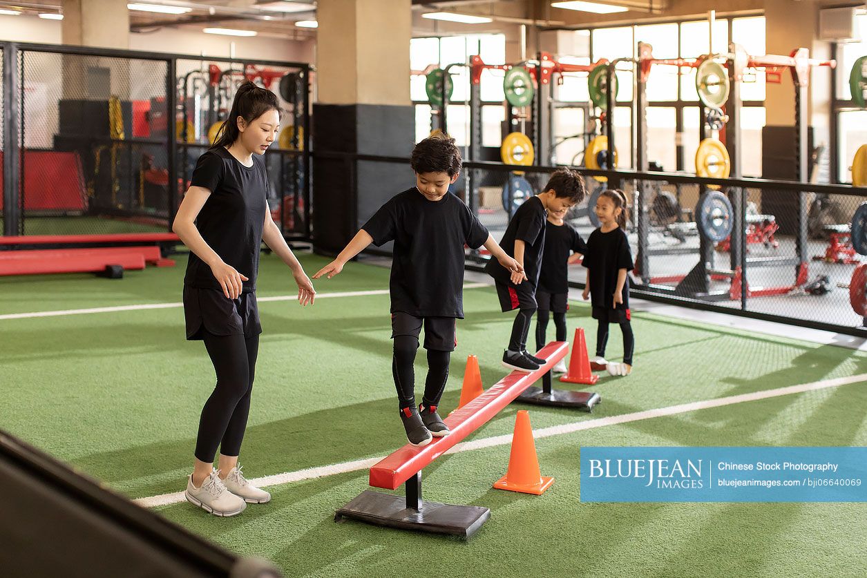 Active Chinese children having exercise class with their coach in gym-High-res stock photo for ...