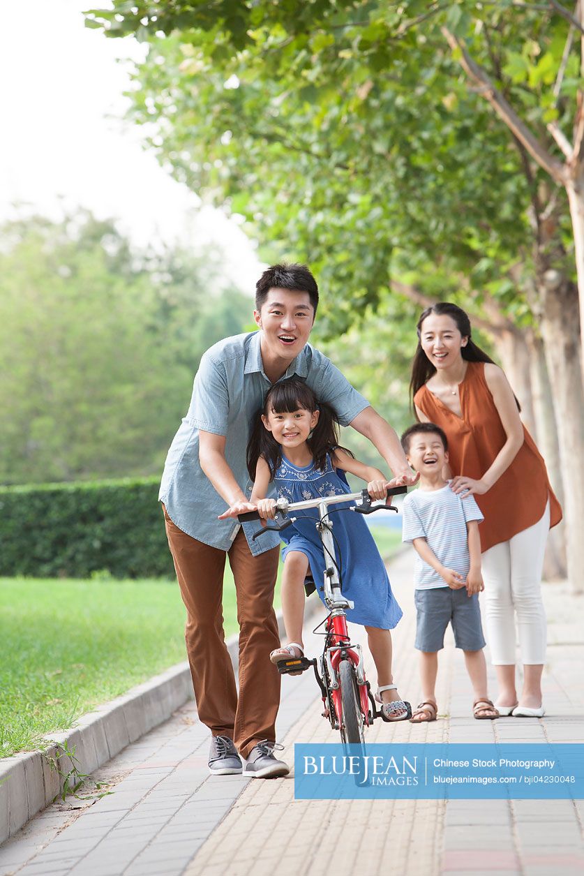 Young Chinese father teaching his daughter to ride a bicycle-High-res ...