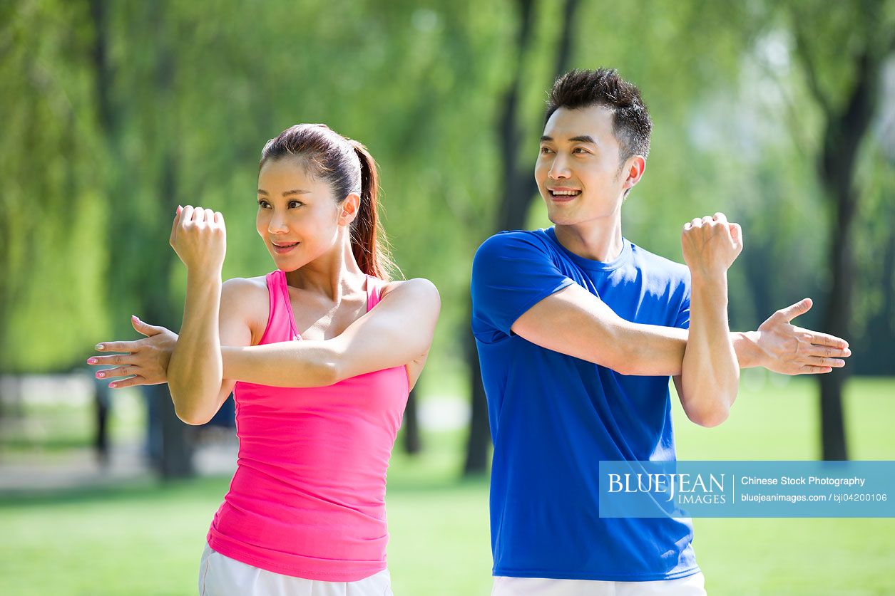 Young Chinese couple stretching in park-High-res stock photo for download