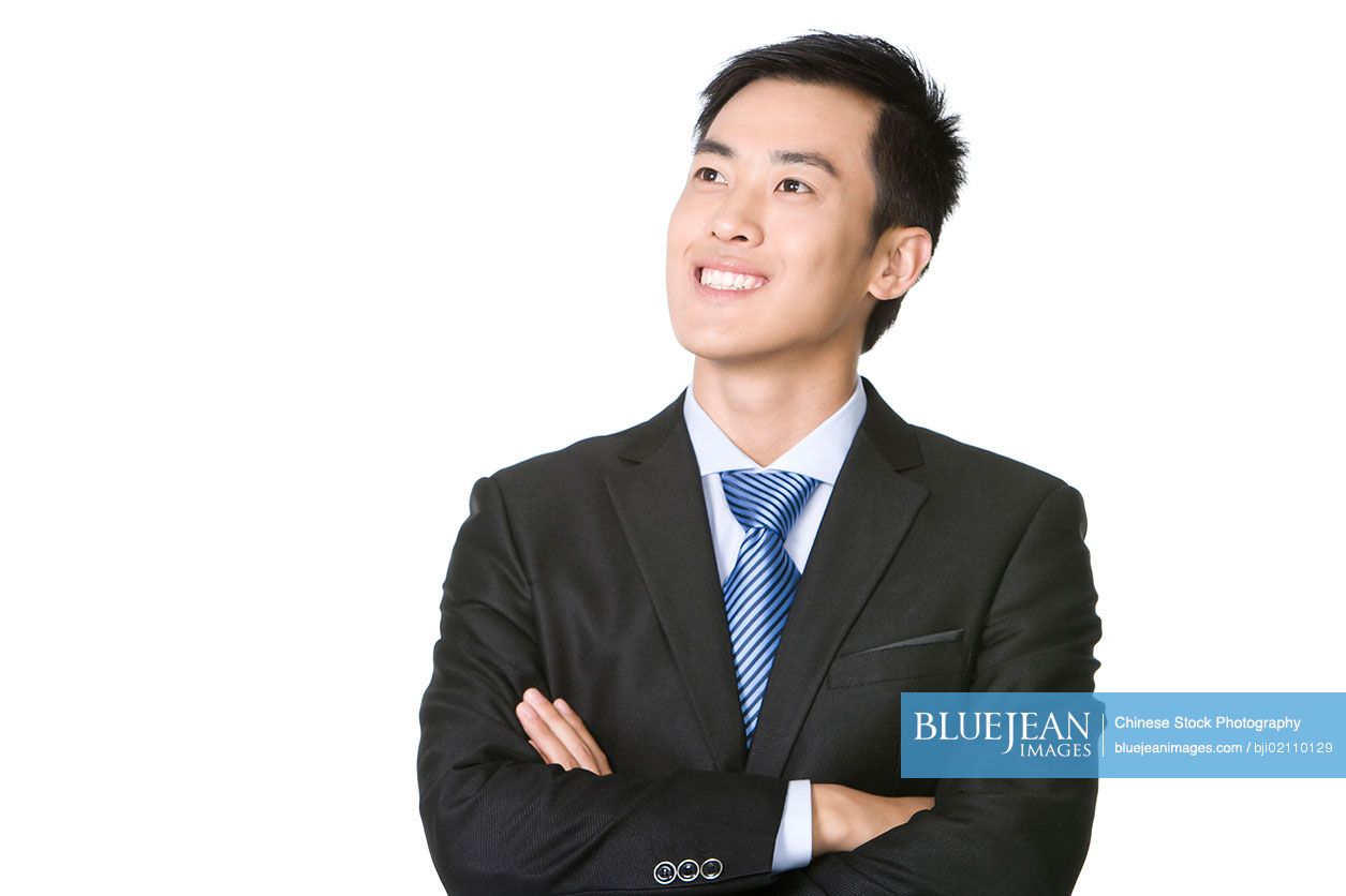 Young Chinese businessman looking up and smiling-High-res stock photo ...
