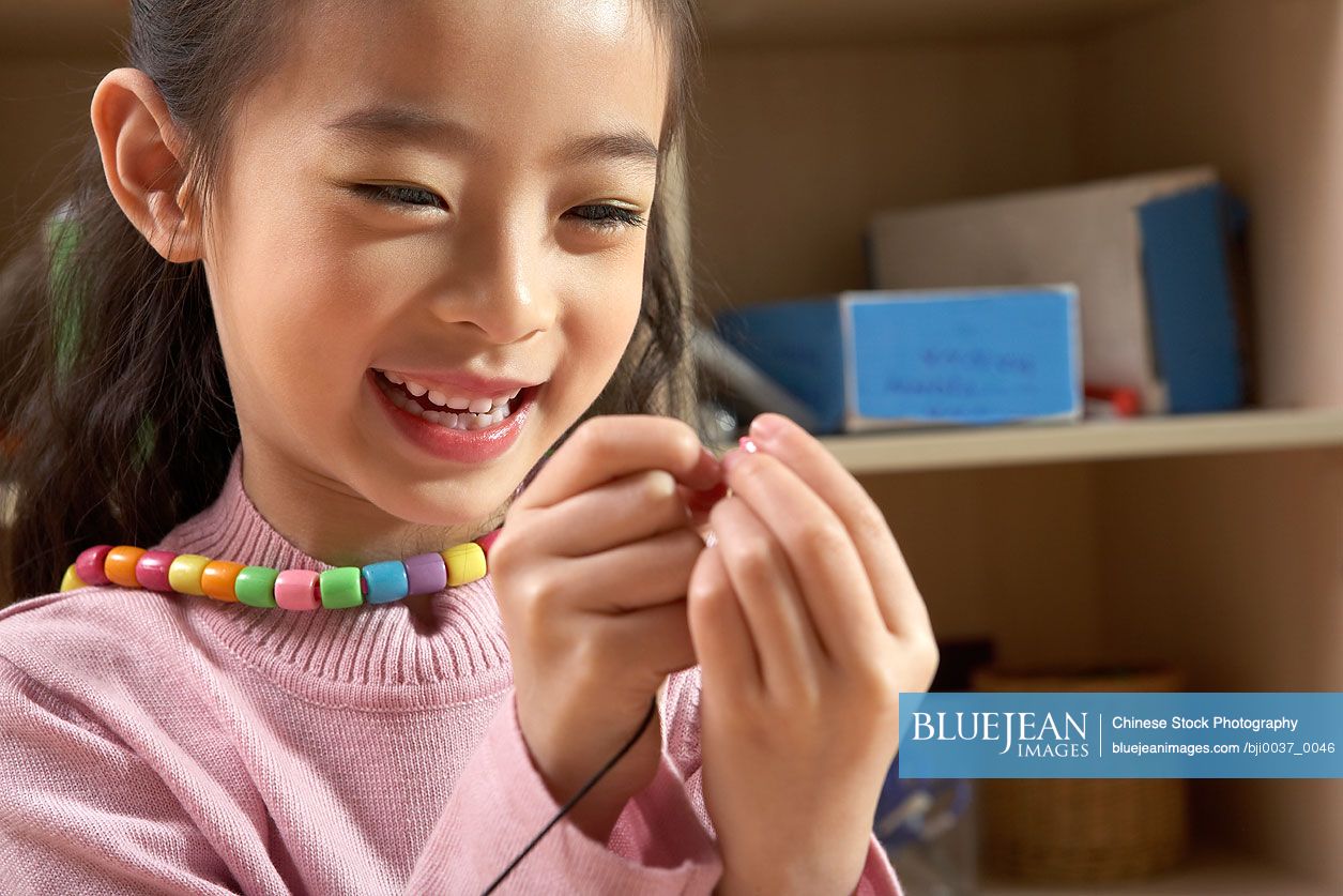 Chinese Girl In Classroom Smiling And Playing With Bead Necklace-High ...