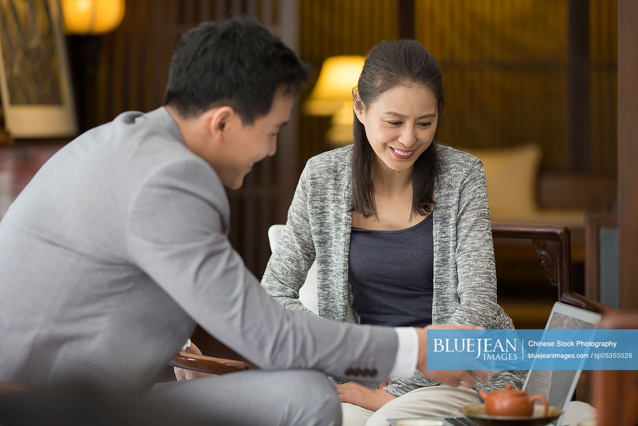 Confident Chinese financial consultant talking with a mature woman-High ...