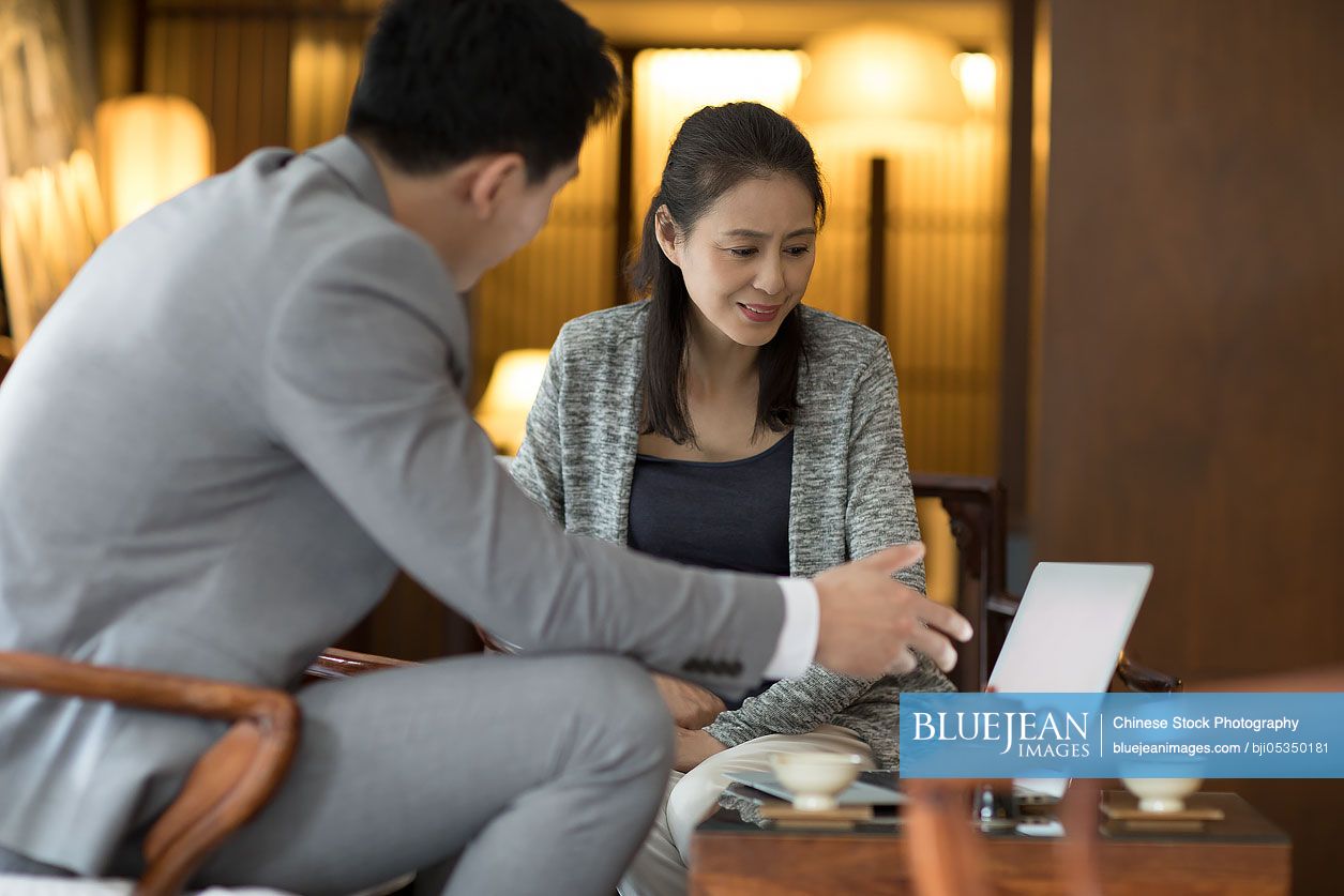 Confident Chinese businessman talking with a mature woman-High-res stock photo for download