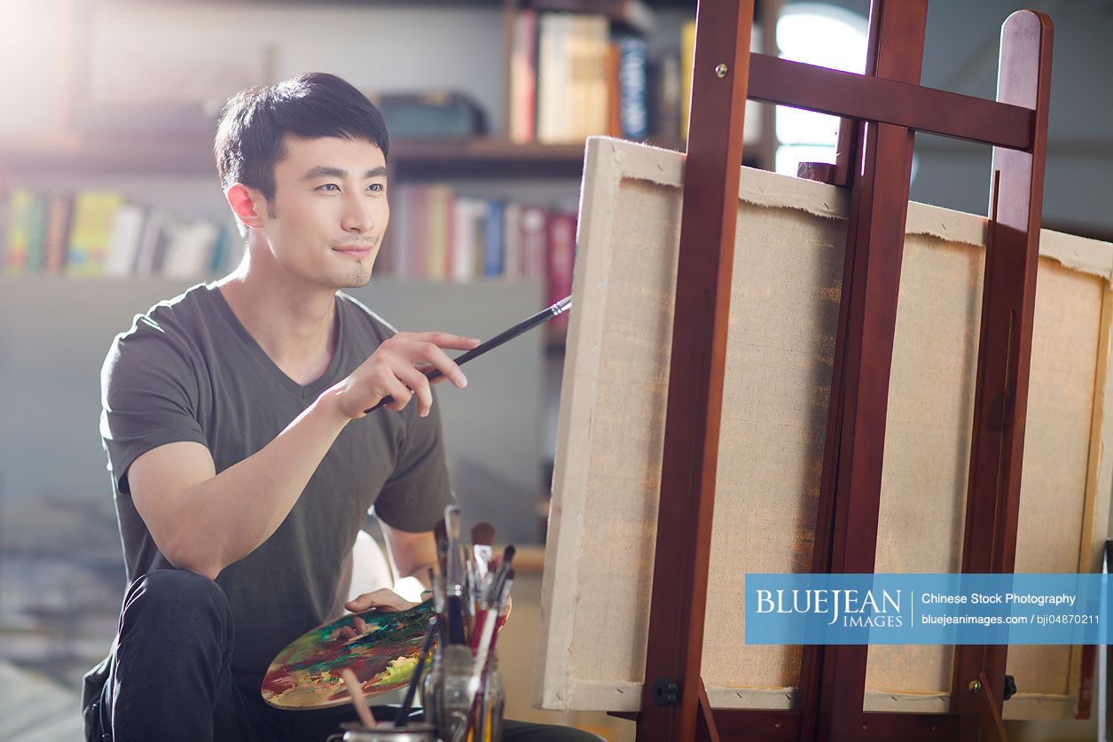 Chinese artist painting in his studio-High-res stock photo for download