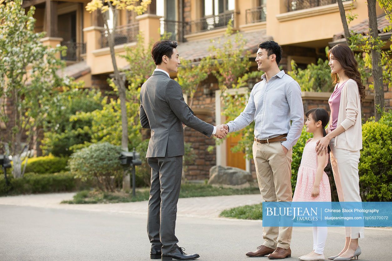 Happy young Chinese family shaking hands with realtor-High-res stock photo for download