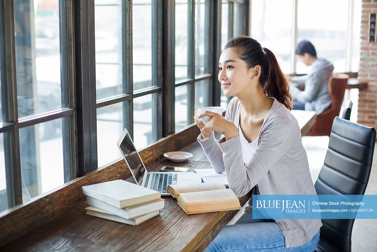 Young Chinese woman studying in cafe-High-res stock photo for download