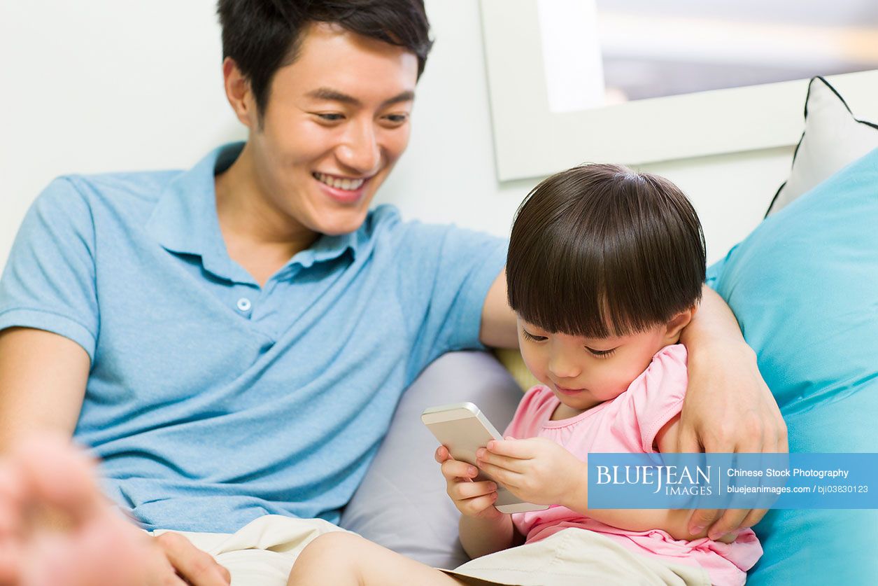 Happy Chinese father and daughter with smart phone-High-res stock photo ...
