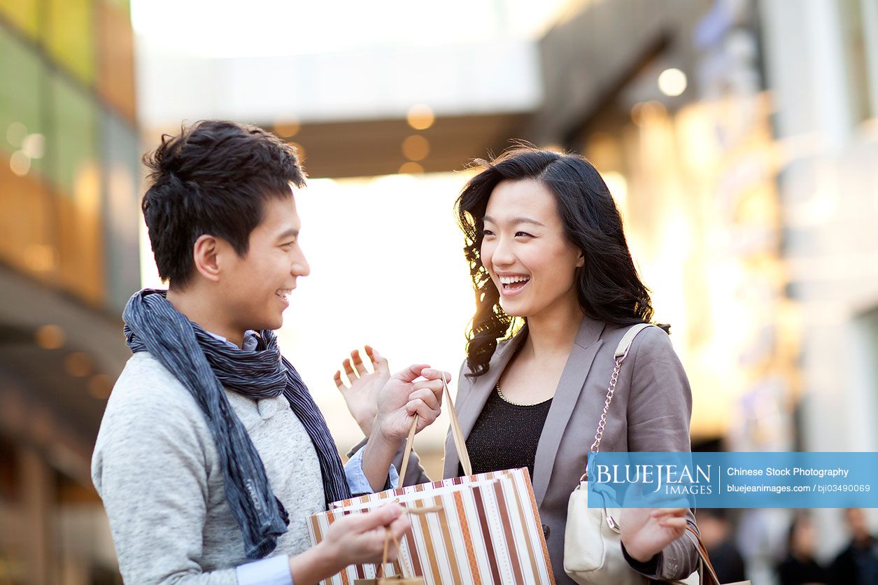 Excited young Chinese woman receiving a surprise gift from boyfriend ...