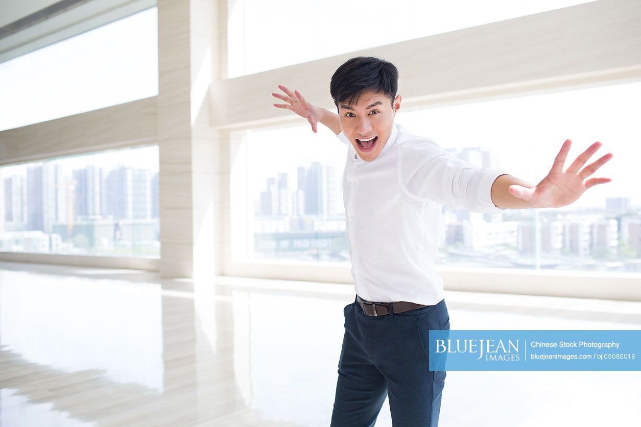 Cheerful young Chinese businessman in office building-High-res stock ...