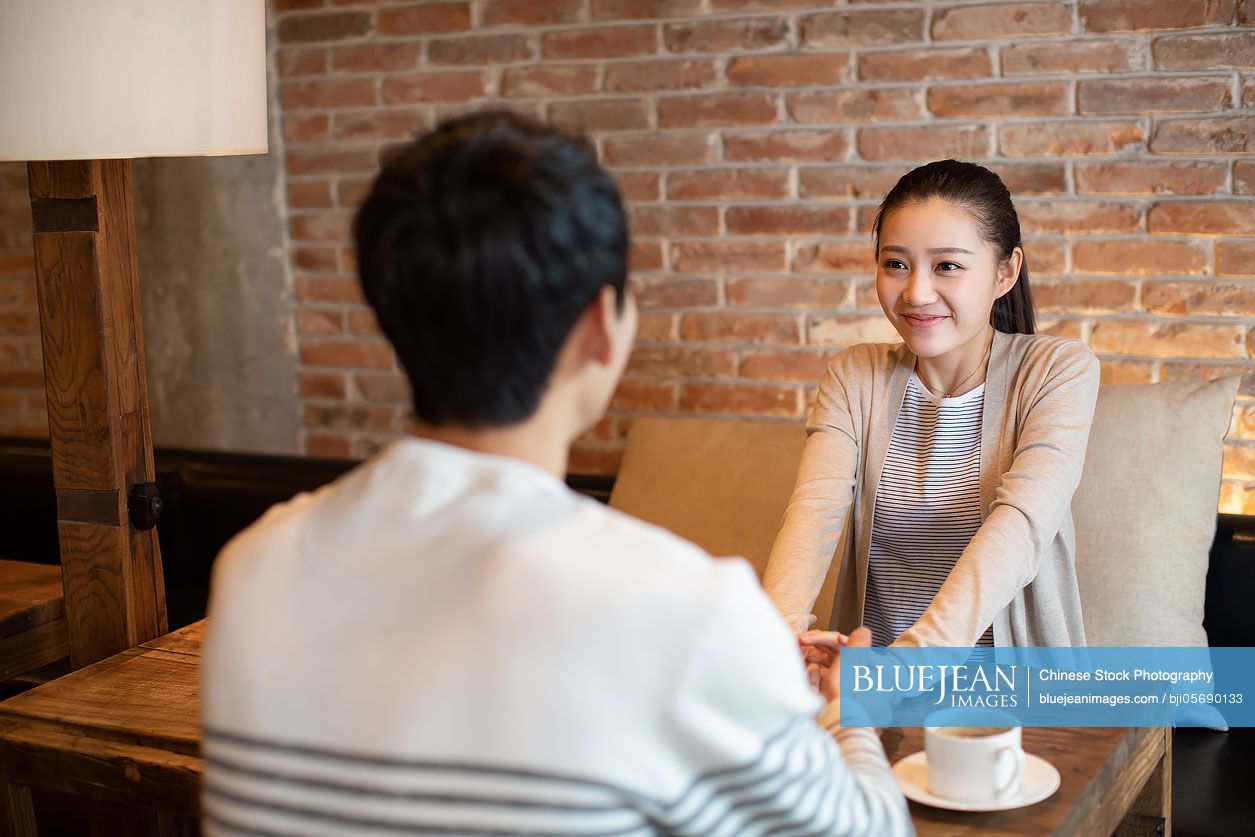 Young Chinese couple dating in coffee shop-High-res stock photo for download