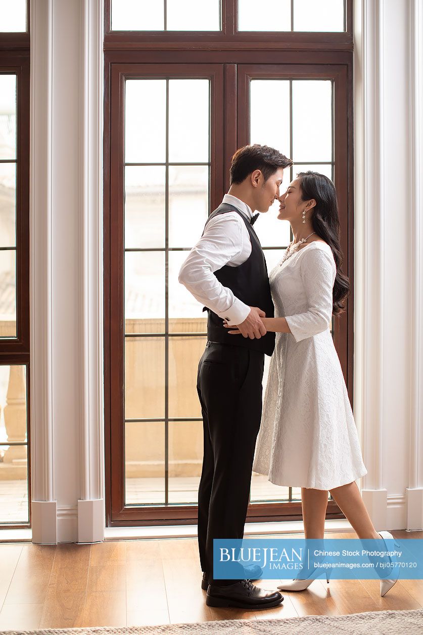 Happy young Chinese couple kissing at home-High-res stock photo for download