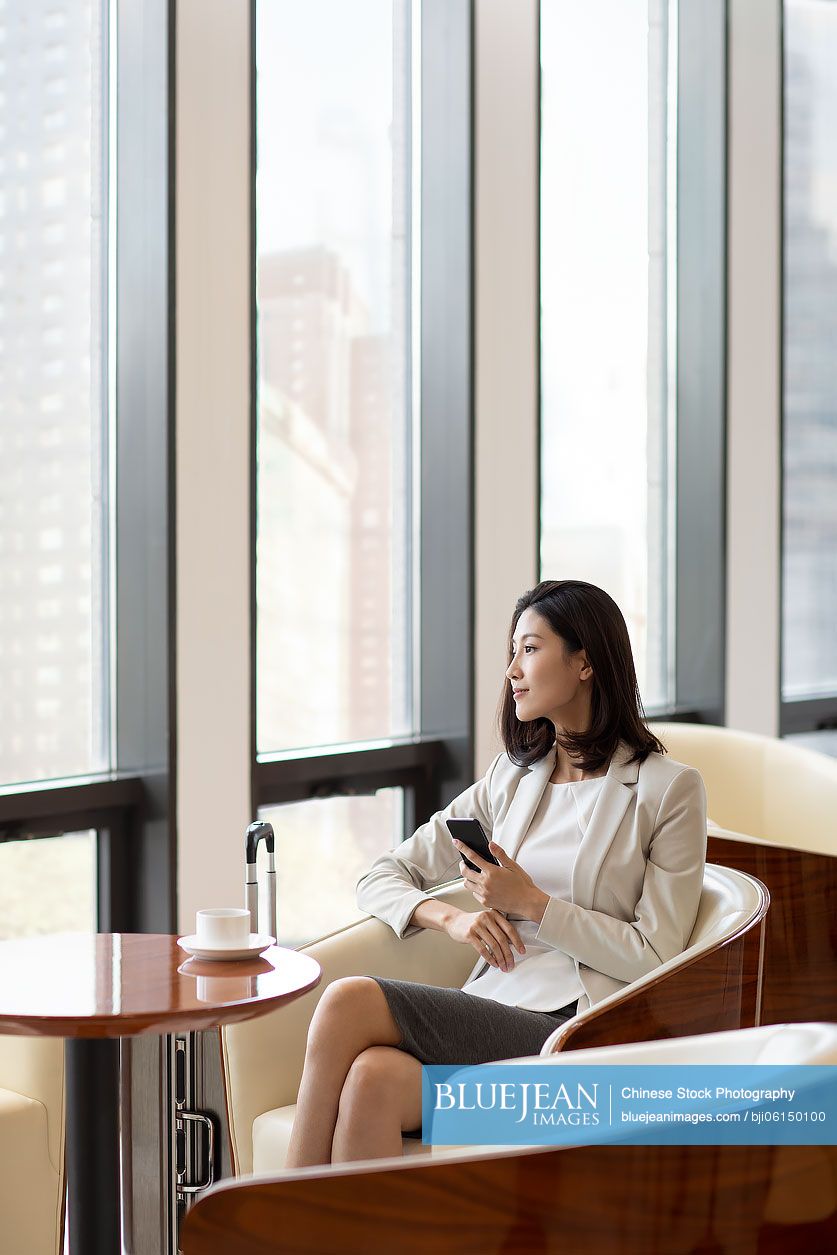 Confident Chinese businesswoman waiting in airport lounge-High-res stock photo for download