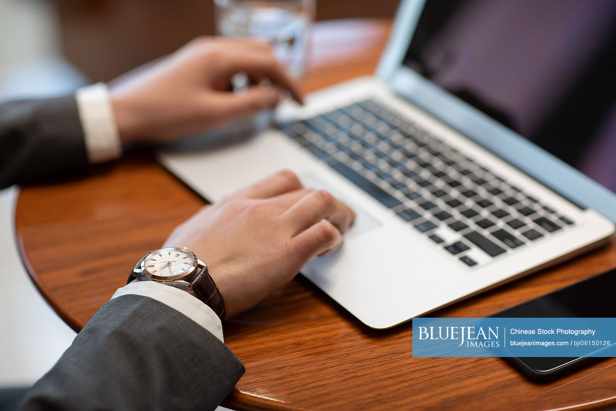 Confident Chinese businessman using laptop-High-res stock photo for download