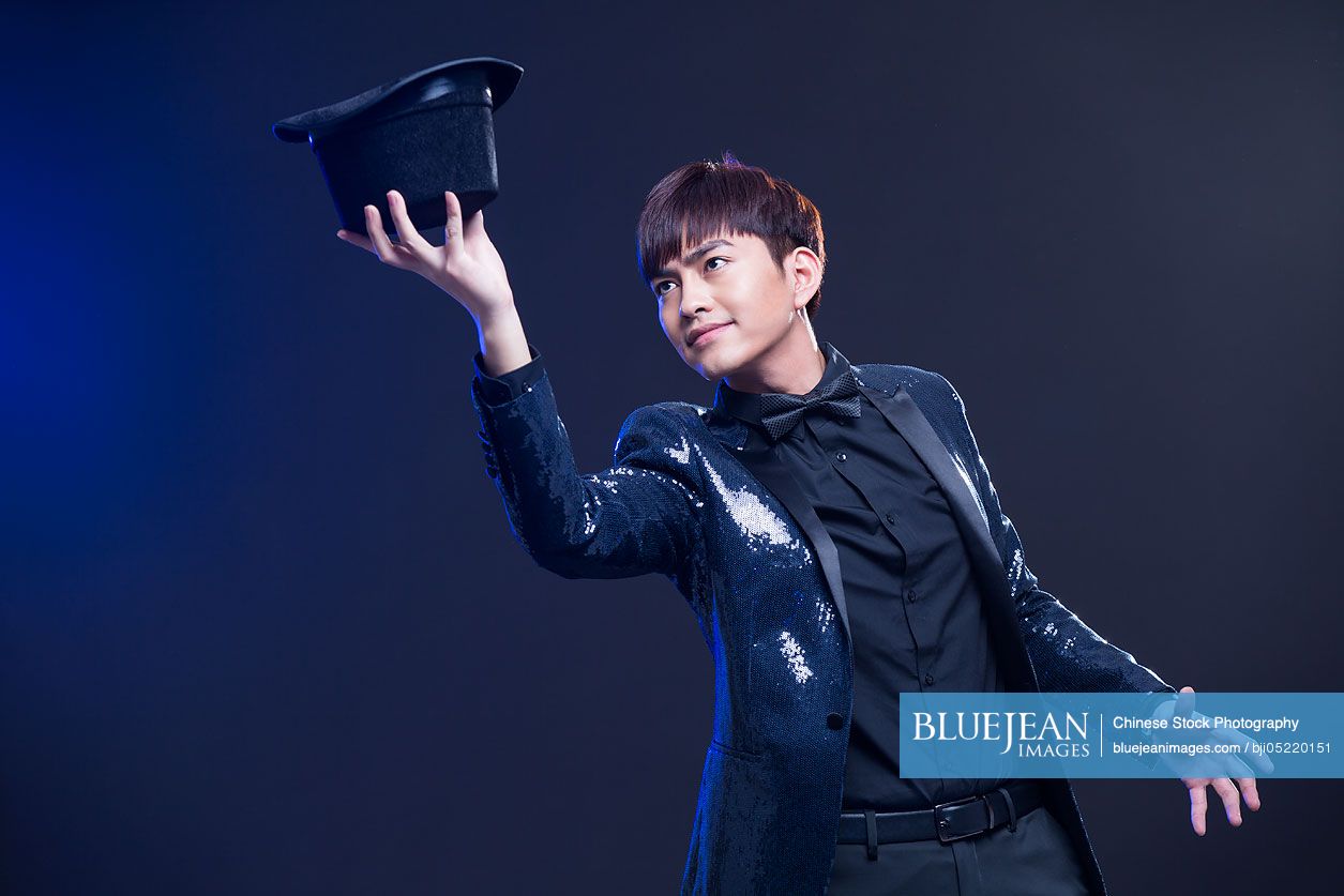 Young Chinese magician performing magic trick-High-res stock photo for ...