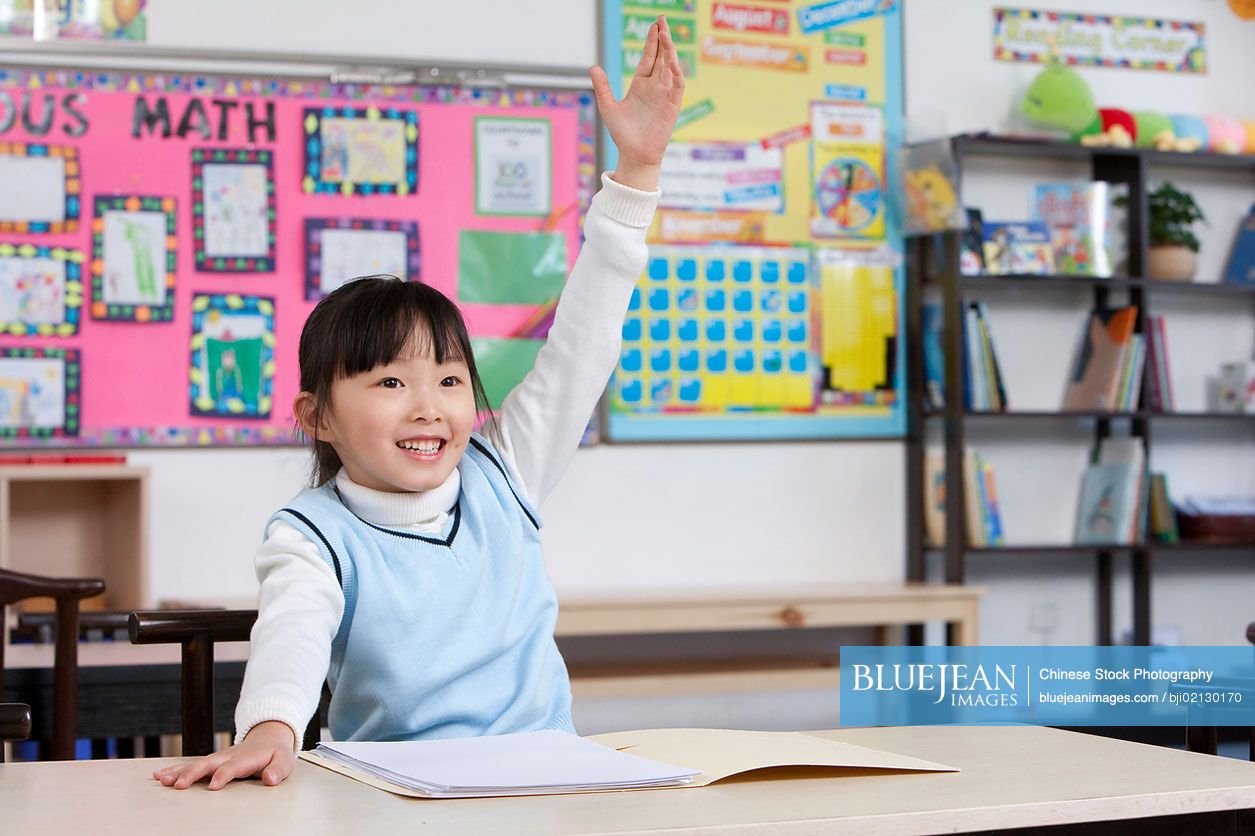 Young Chinese student raising her hand in classroom-High-res stock ...