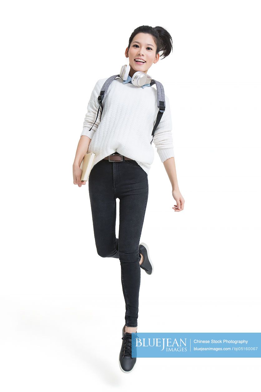 Cheerful female college student jumping-High-res stock photo for download