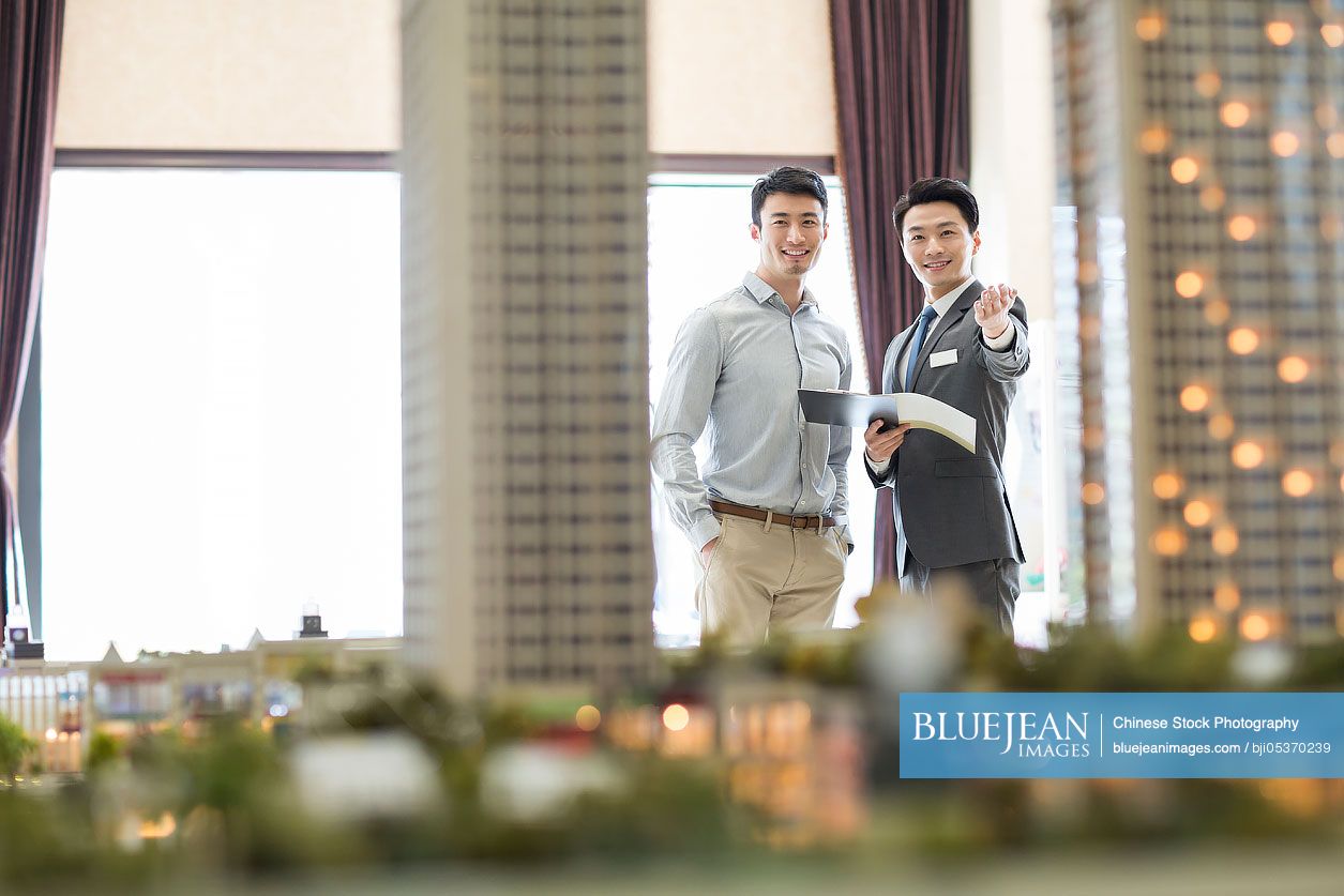 Chinese realtor showing architectural model to young man-High-res stock ...