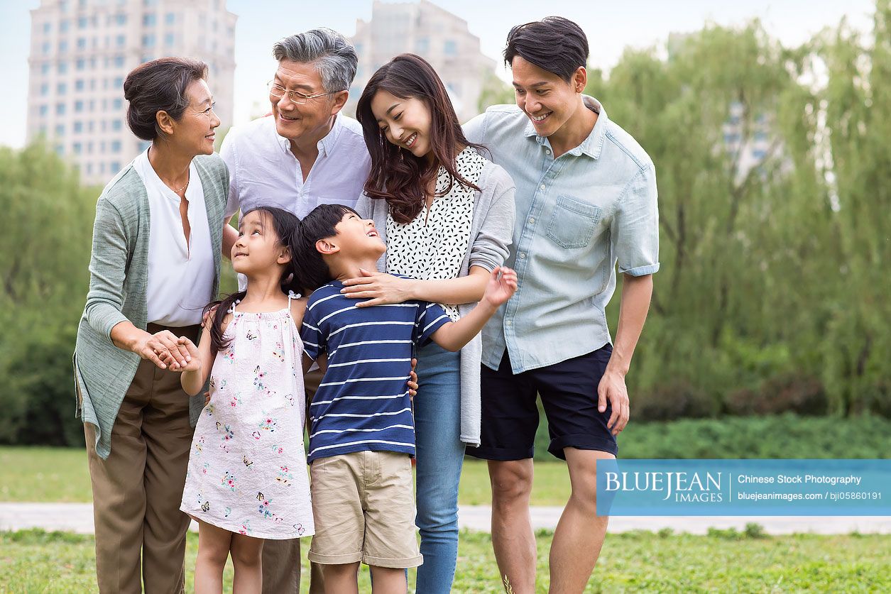 Happy Chinese family standing on grass-High-res stock photo for download