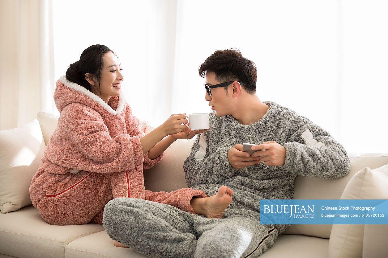 Happy young Chinese couple relaxing on sofa-High-res stock photo for ...