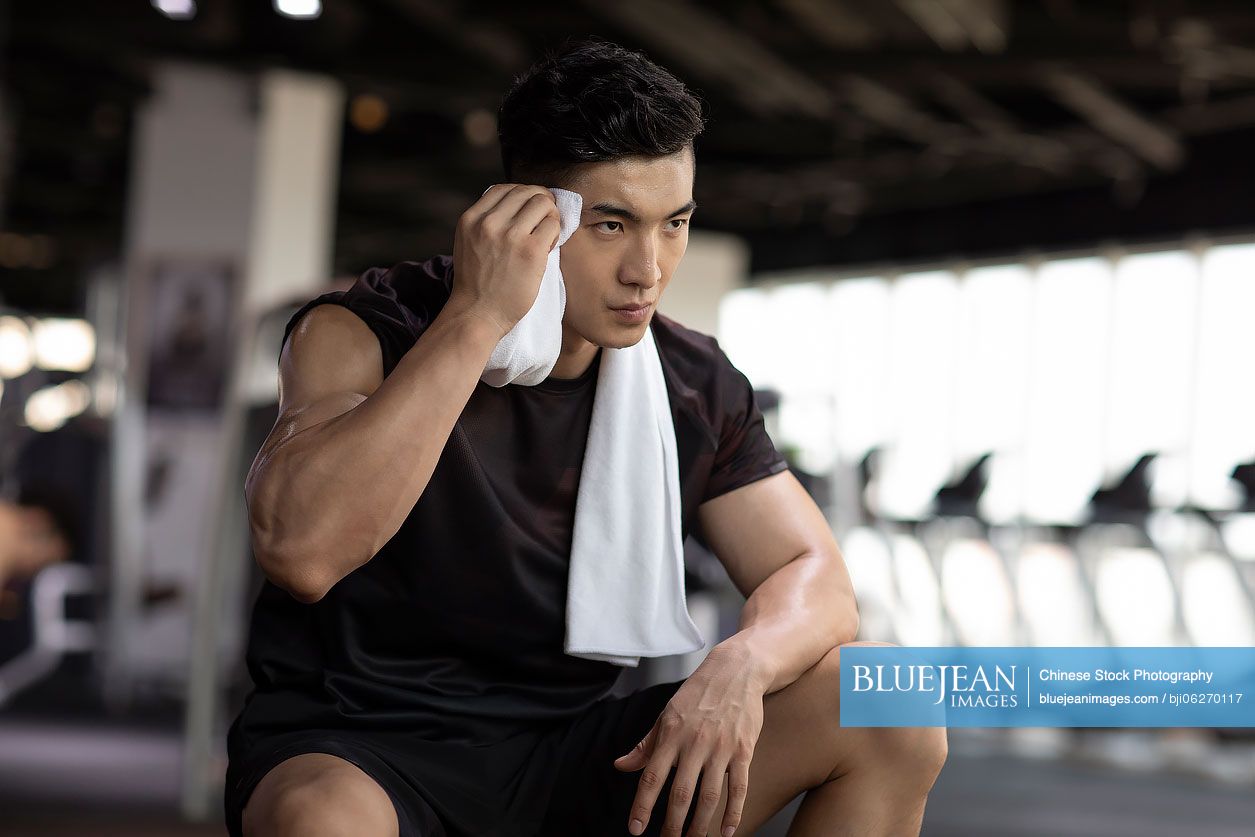 Young Chinese man taking a break from workout at gym-High-res stock ...